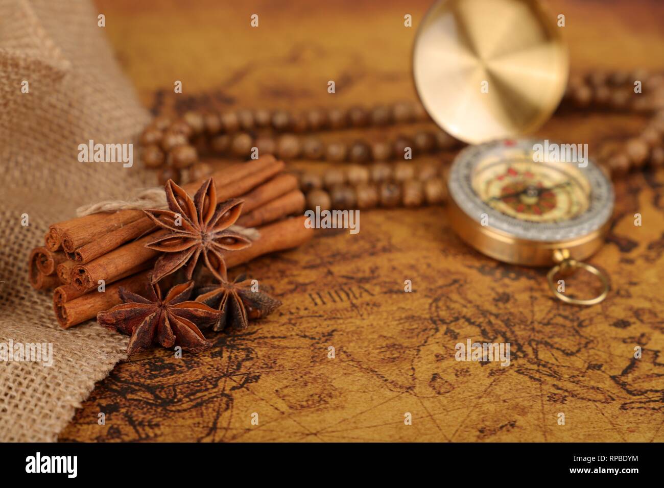Vintage compass and cinnamon spices on a old world map - trade and ...