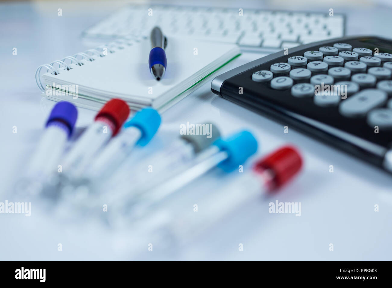 notepad and calculator next to bottles for samples used in hospitals or ...