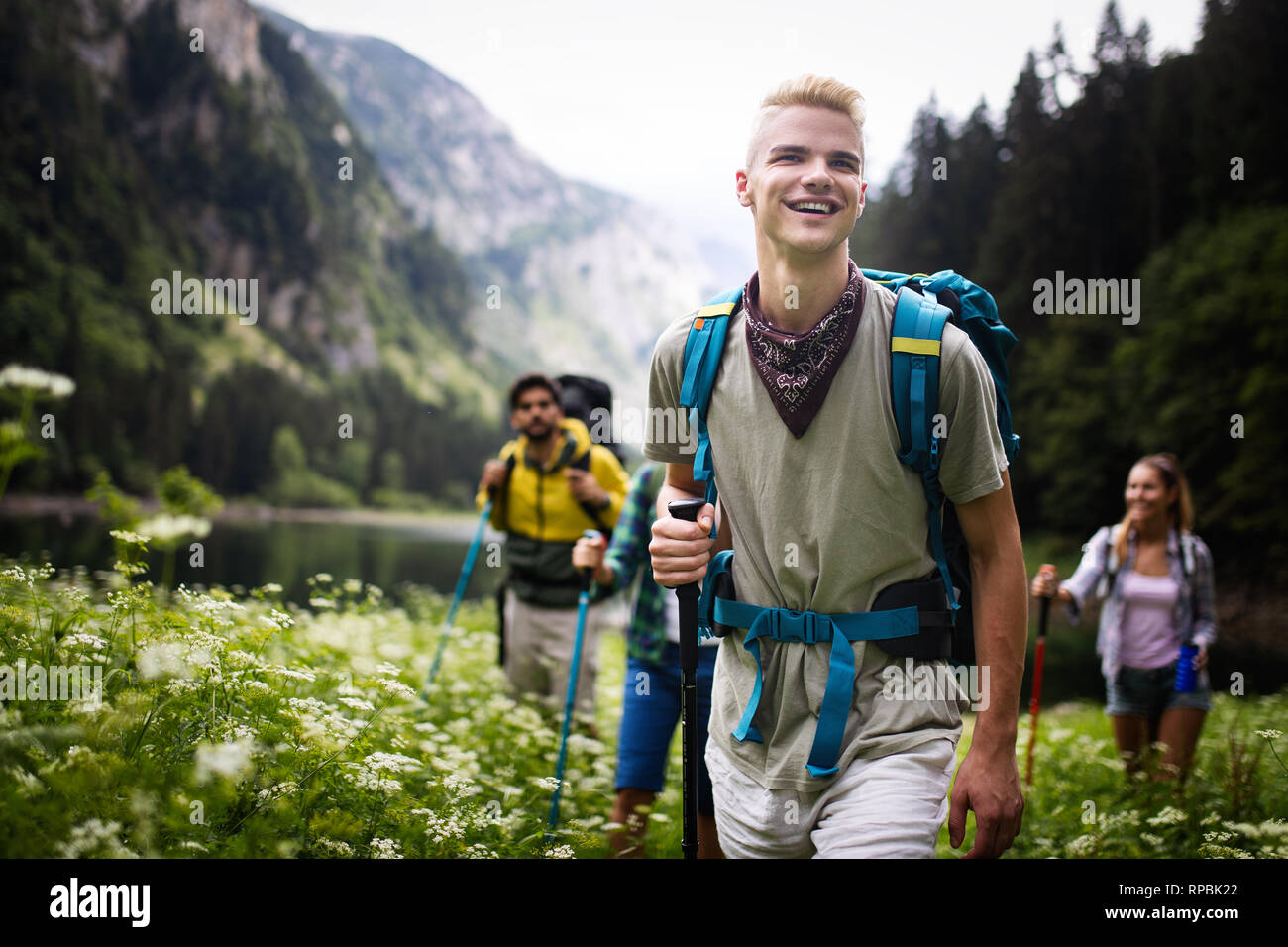 Group of happy friends with backpacks hiking together Stock Photo - Alamy