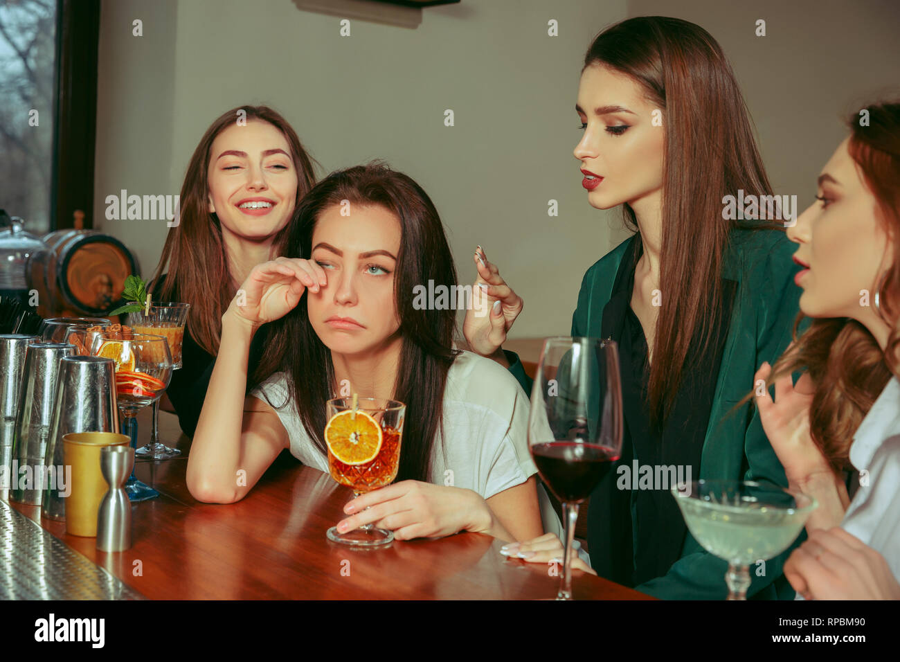 Stress. Female friends having a drinks at bar. They are sitting at a ...