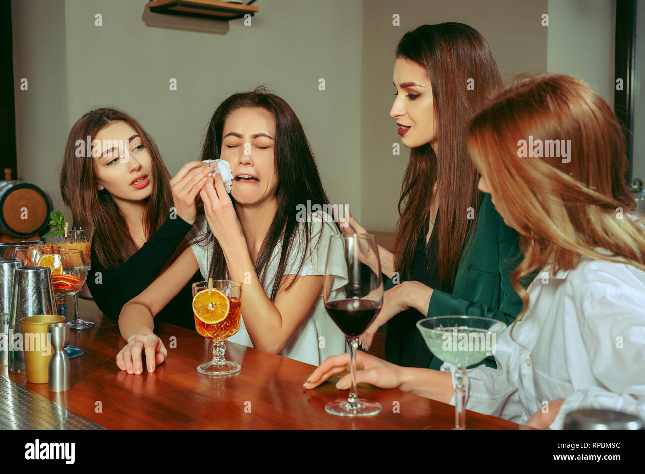 Stress. Female friends having a drinks at bar. They are sitting at a ...