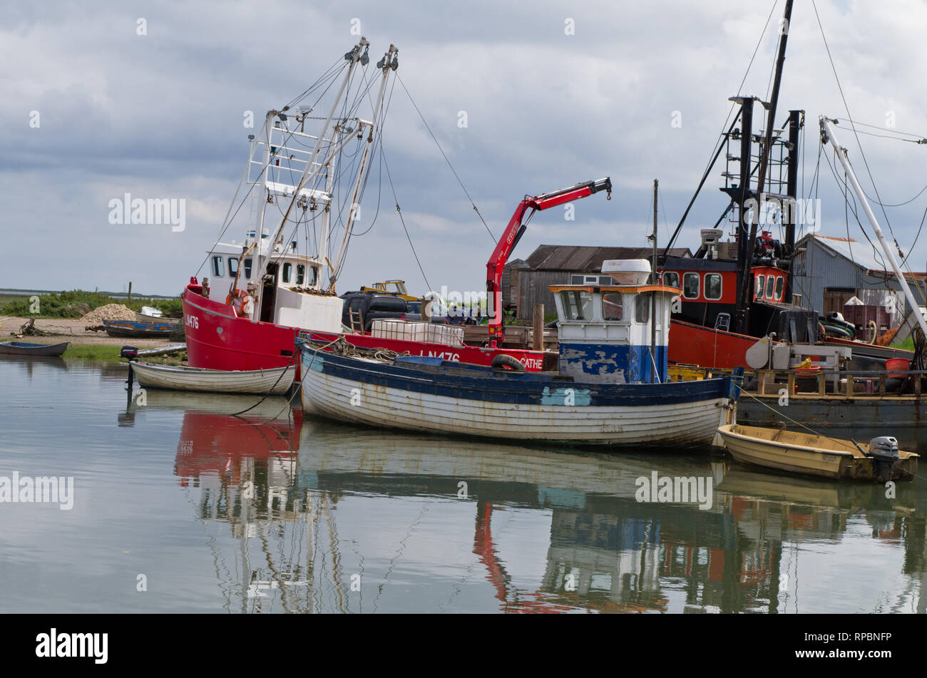 Colourful fishing boats at anchor in the harbour at Brancaster Staithe ...