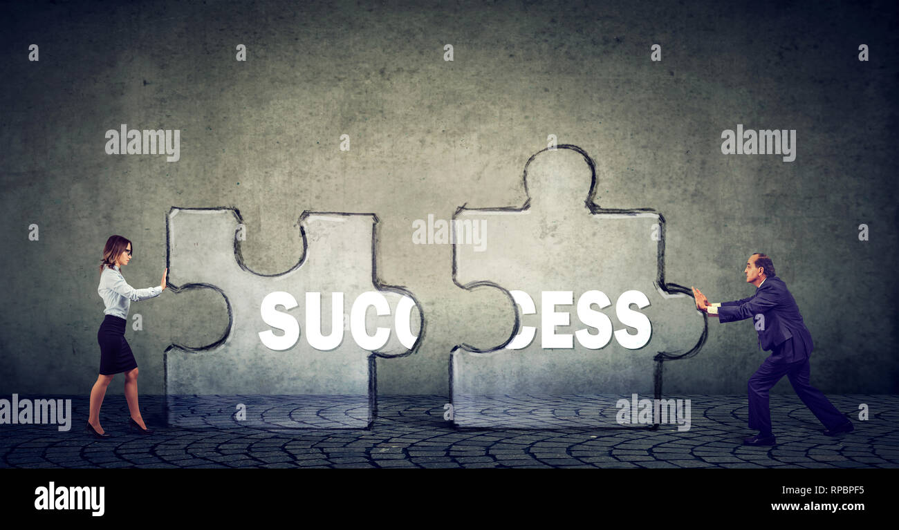 Two business people man and woman working together in tandem to put up ...