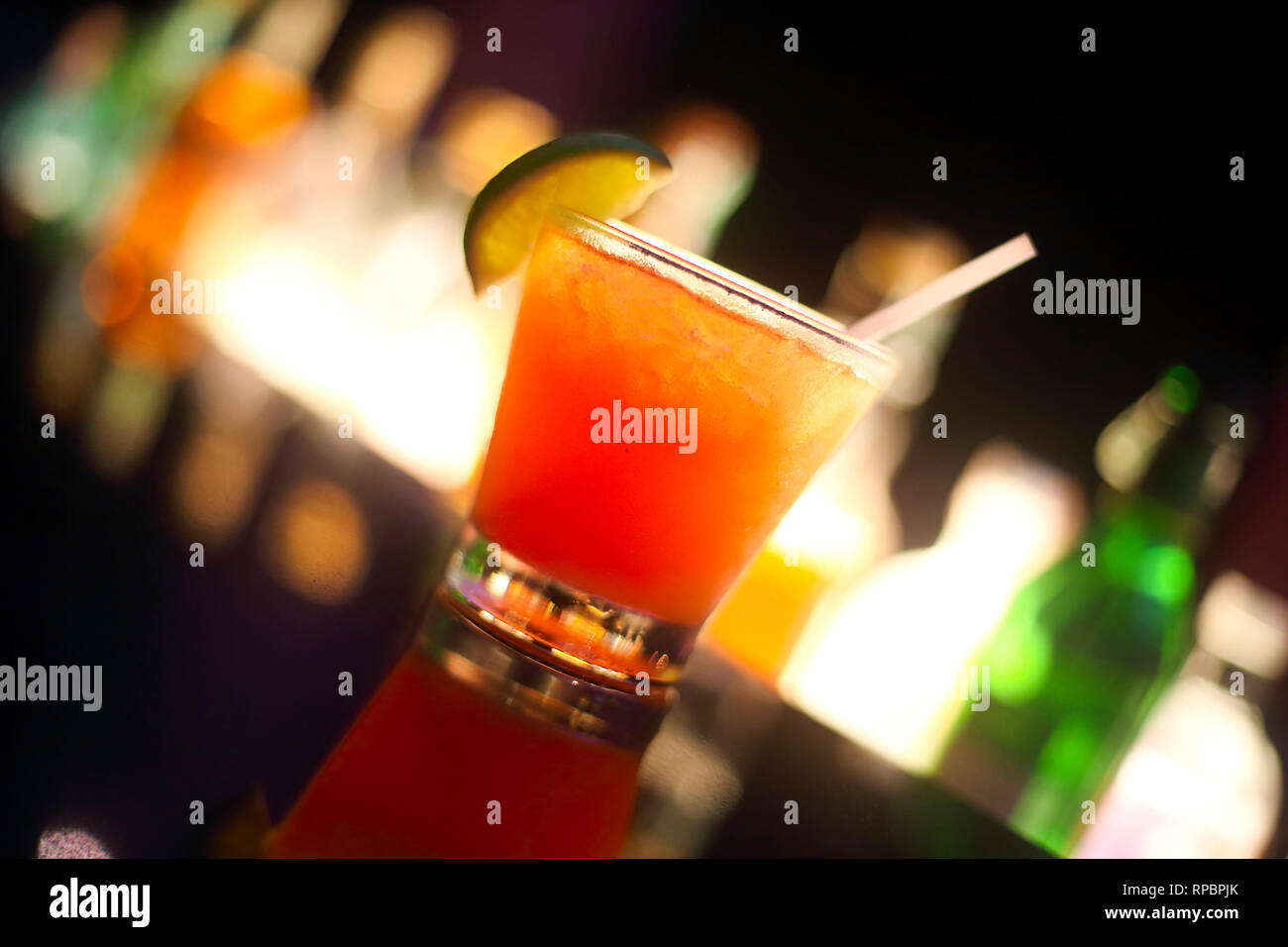 Tequila sunrise cocktail on night bar background Stock Photo - Alamy