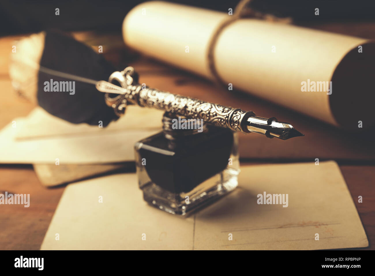 vintage feather pen with ink bottle and old paper roll Stock Photo - Alamy