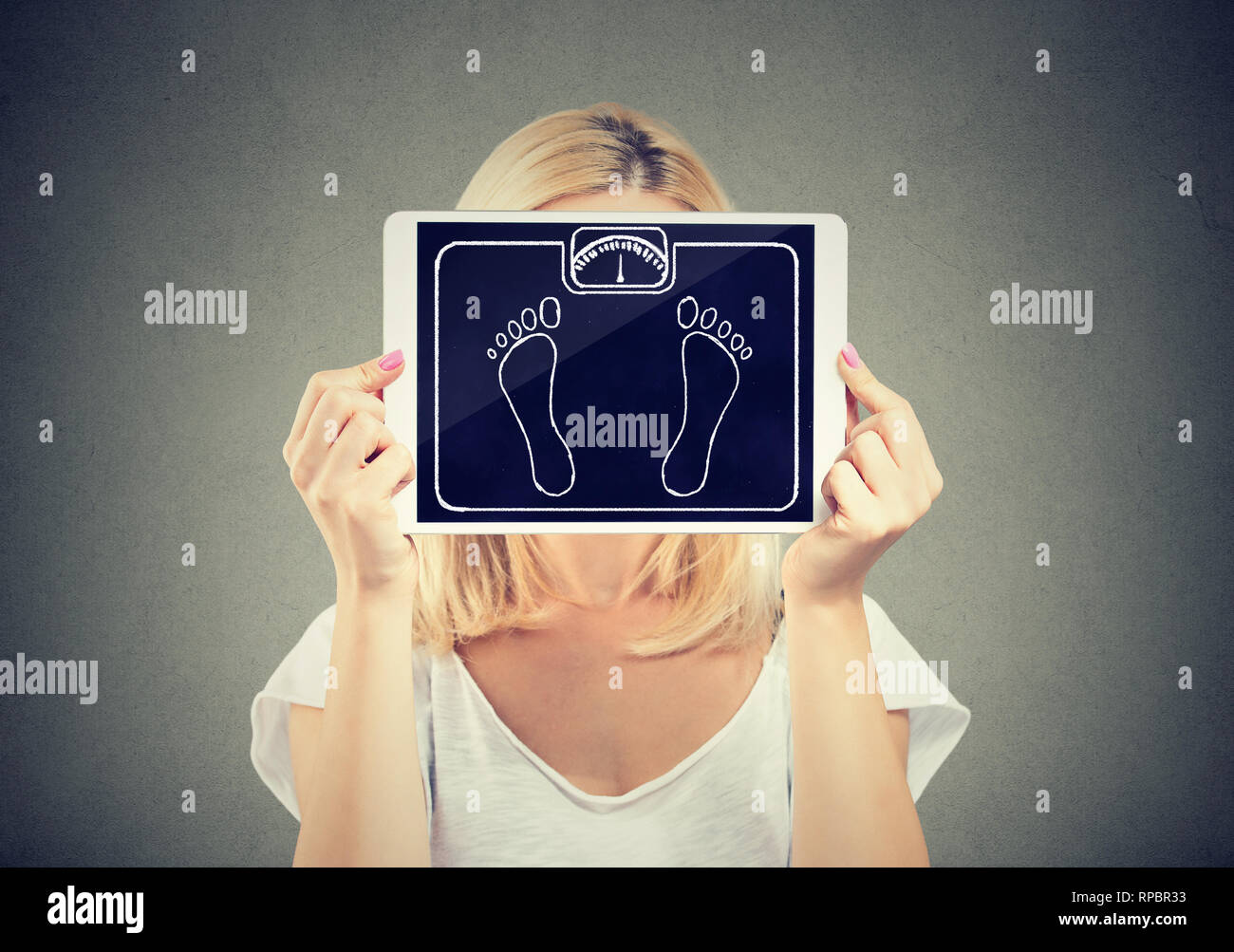 Young woman holding tablet weight scale in front of her face Stock ...