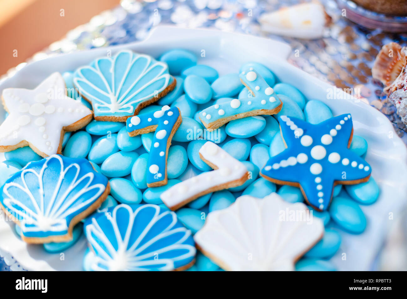 White shell plate full of chocolate candies with blue icing, cookies ...