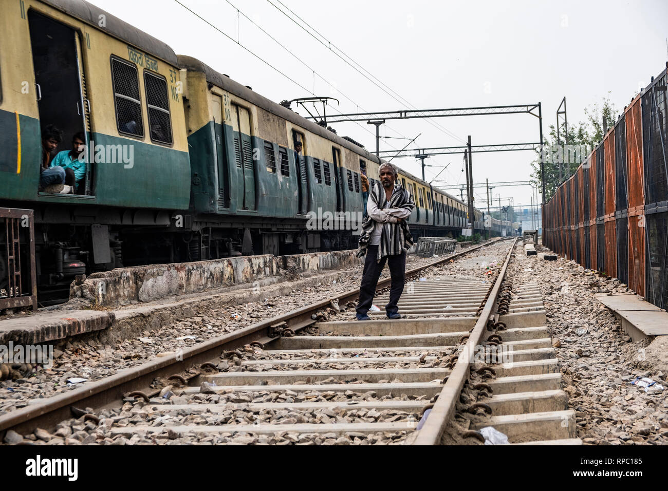 A man watching a local train pass him by Stock Photo - Alamy