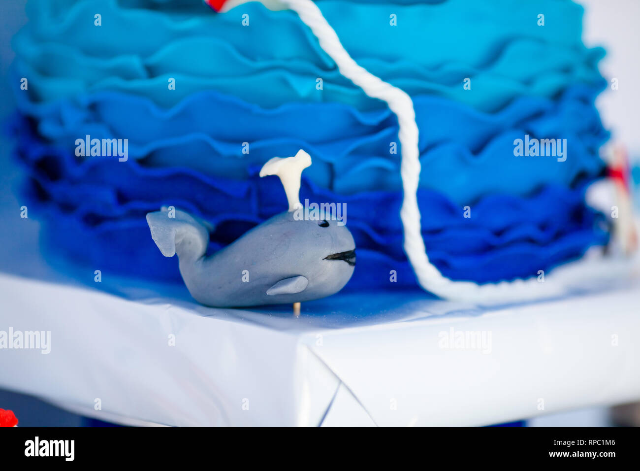 Huge blue birthday cake with sweet whale and lifebuoy and funny ship on ...