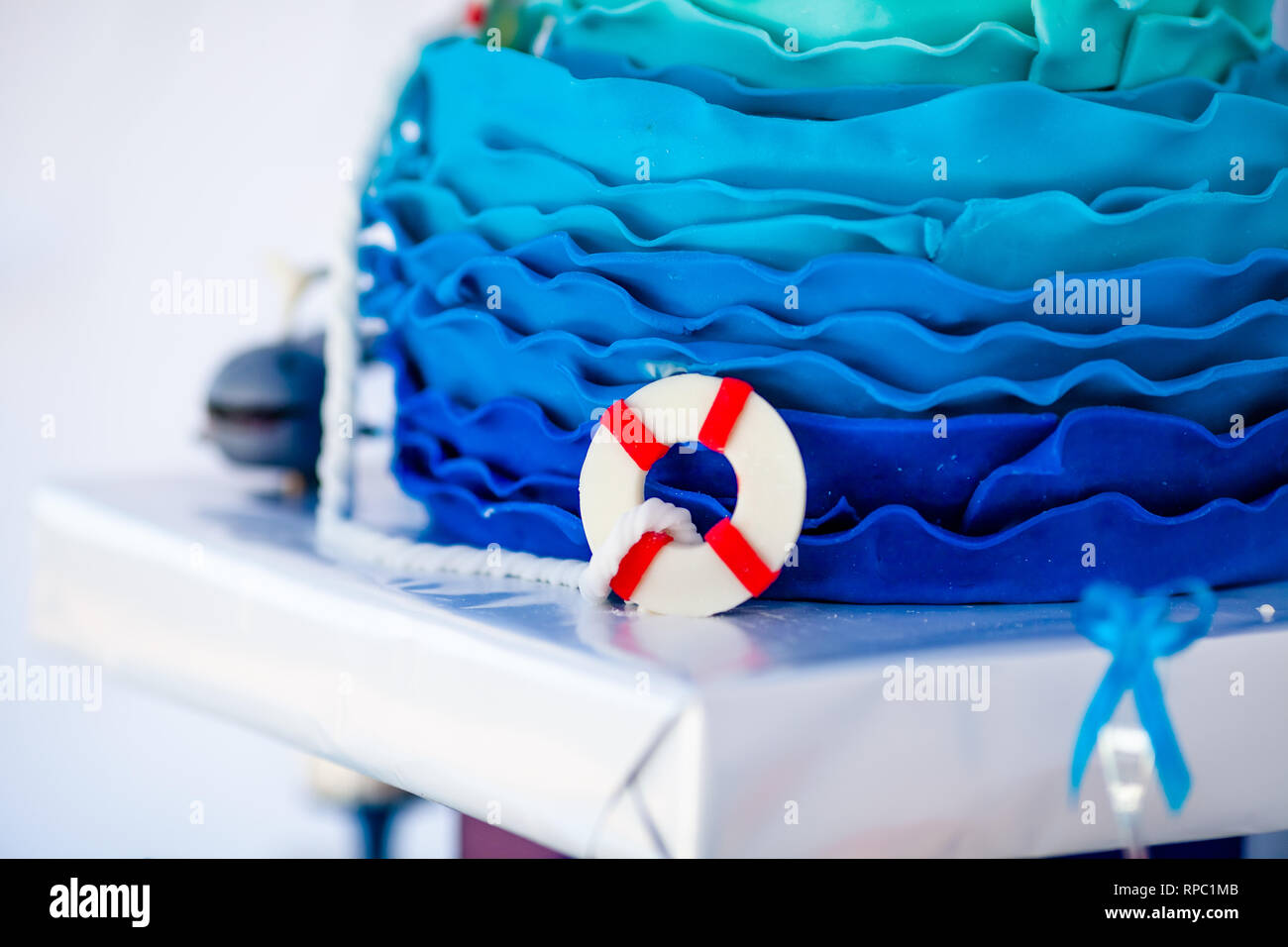 Huge blue birthday cake with sweet whale and lifebuoy and funny ship on ...