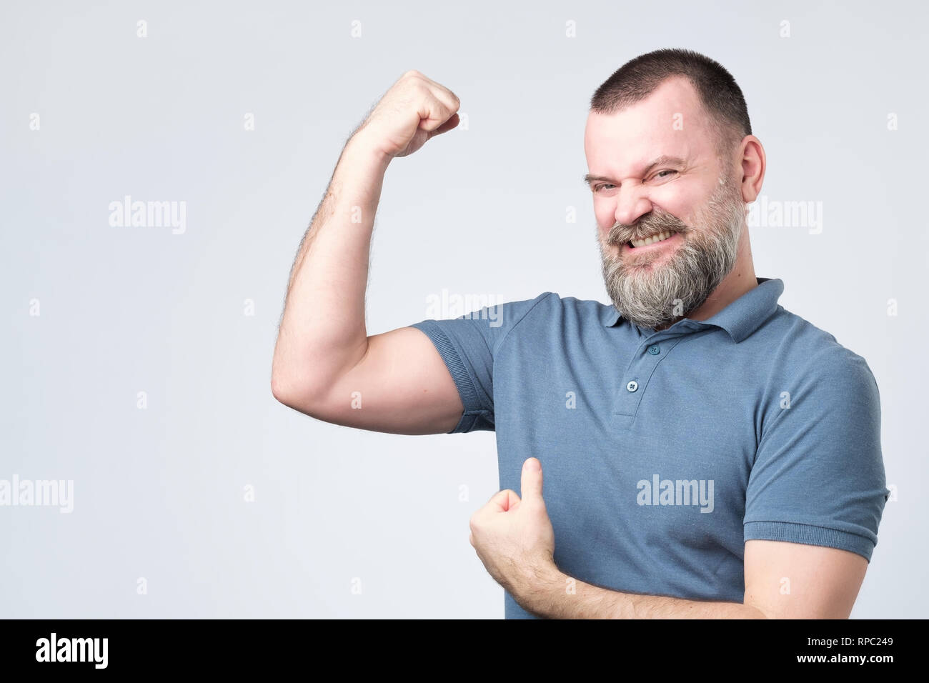 Handsome middle age european bearded man over showing arm muscle Stock ...
