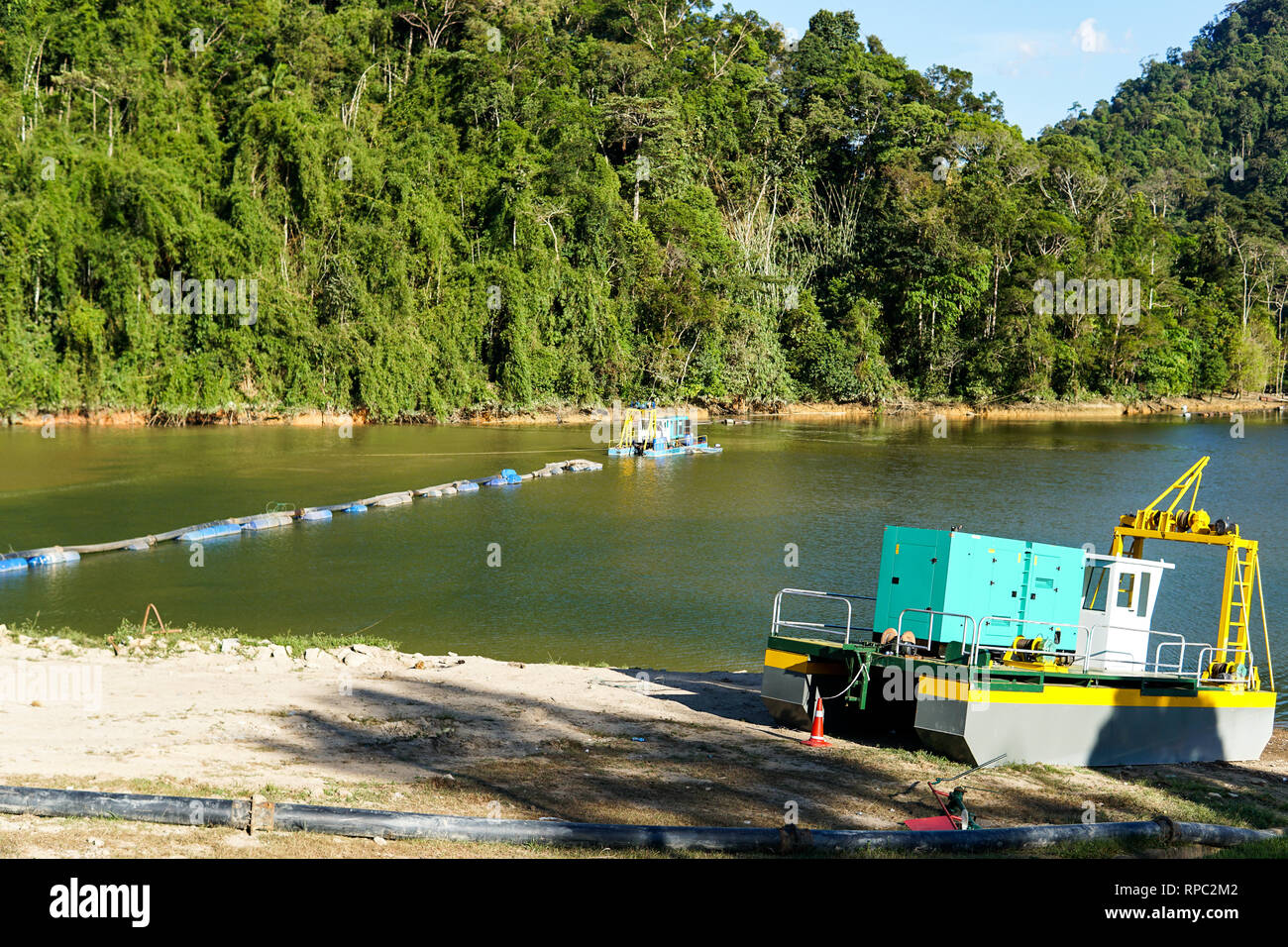Sand dredging boat ,pump and excavator removing sand from the river bed ...