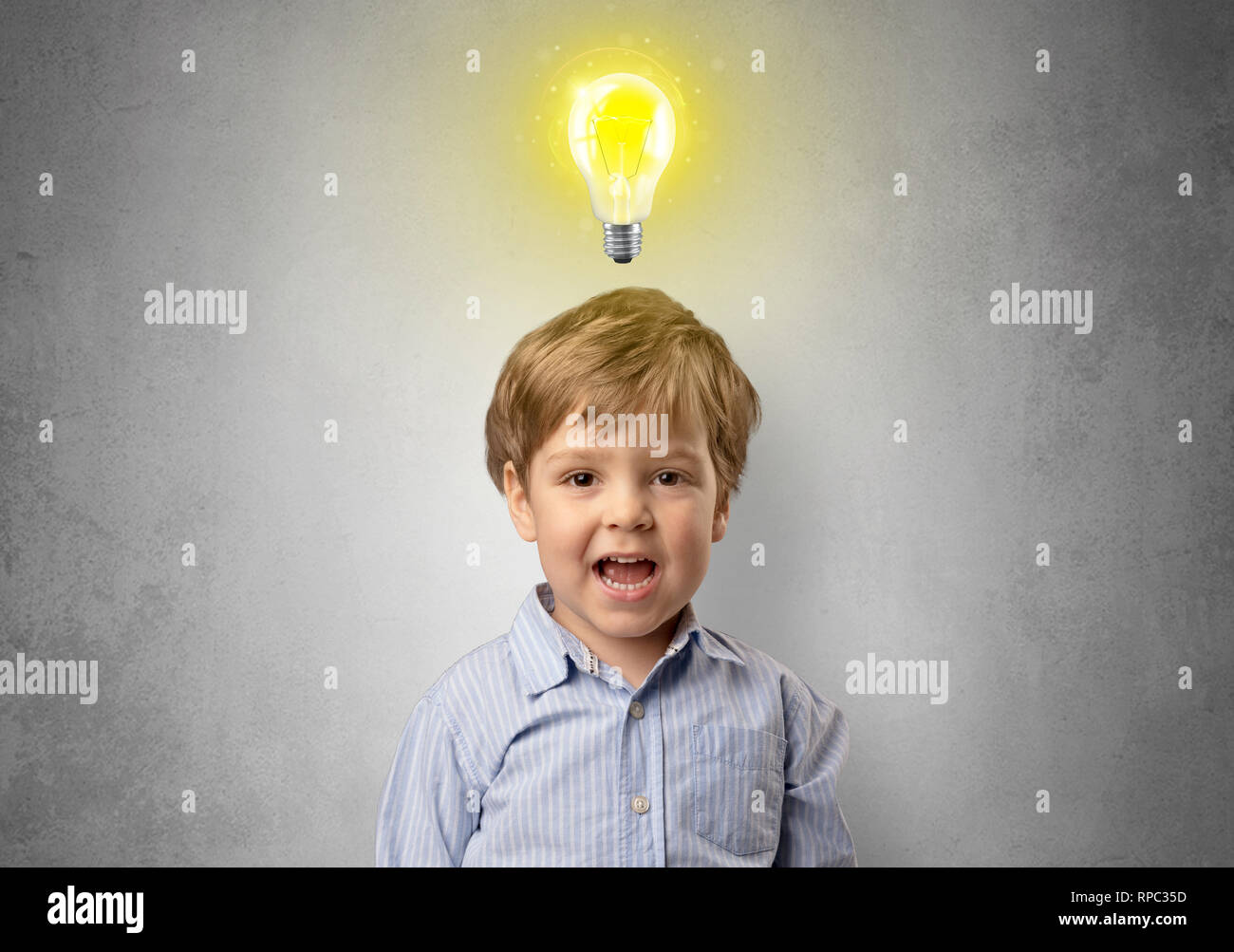 Adorable little kid mull over in front of a grey wall with idea symbol ...