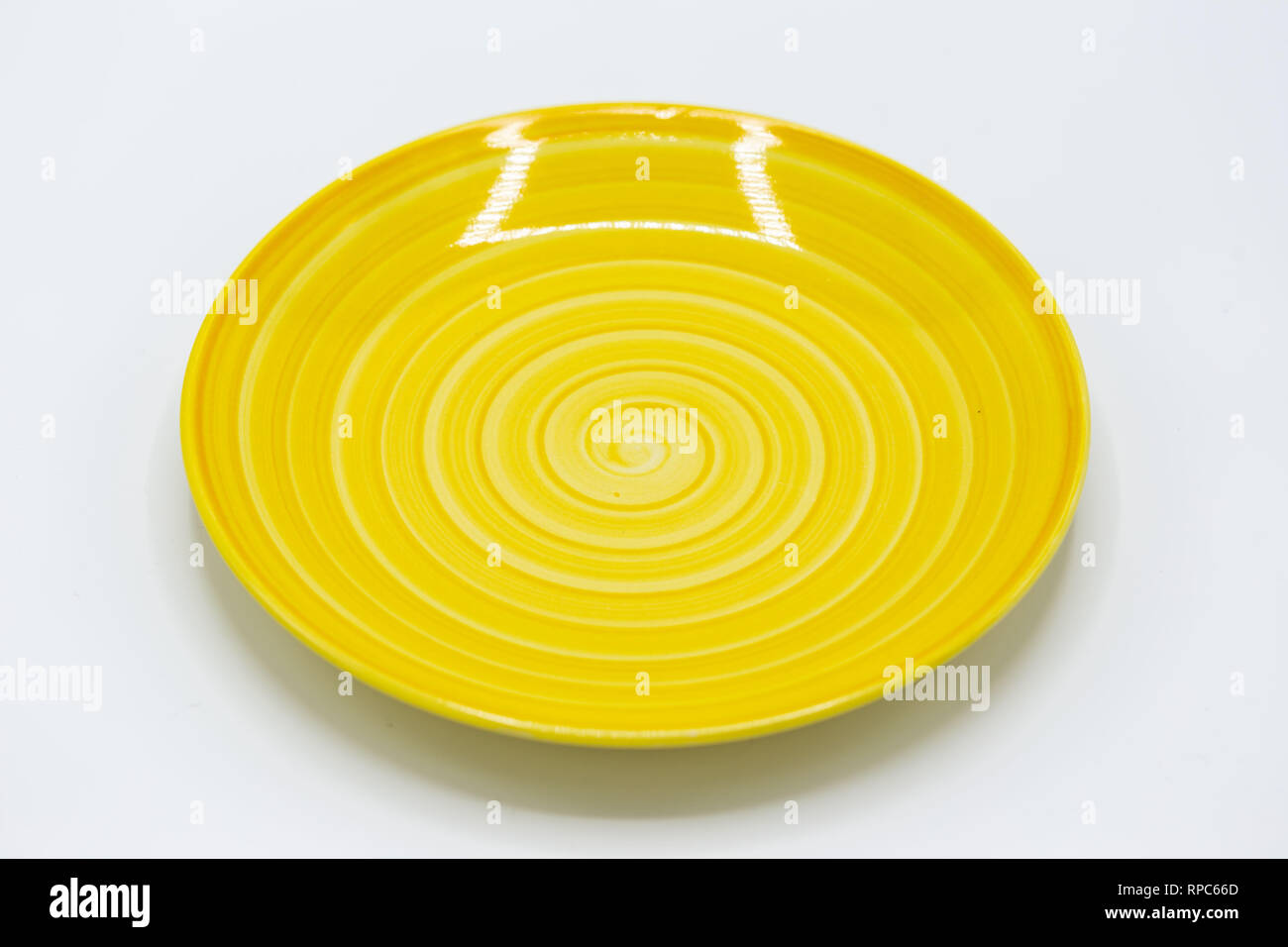 a round yellow plate with a circular swirl pattern Stock Photo - Alamy
