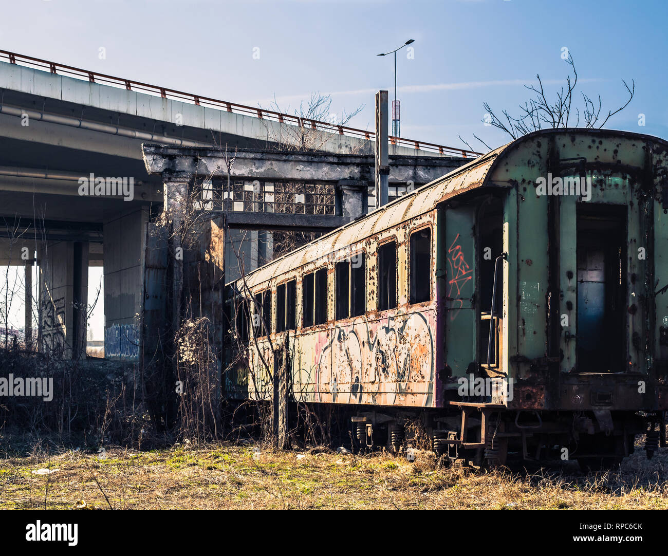 An old abandoned train is parked under the highway overpass Stock Photo ...