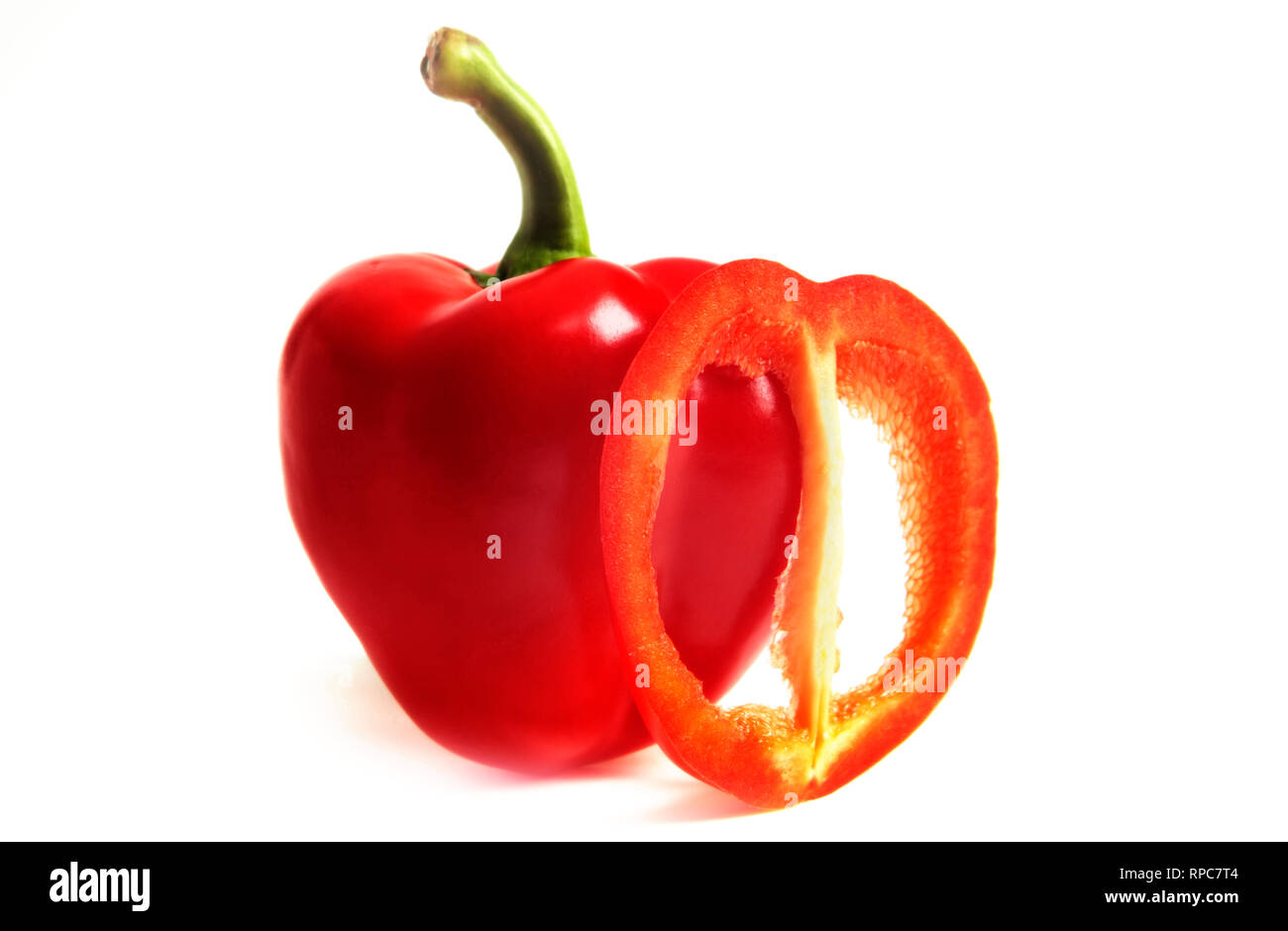 Stunning peppers. Beautiful red color. A paprika slice stands in front ...