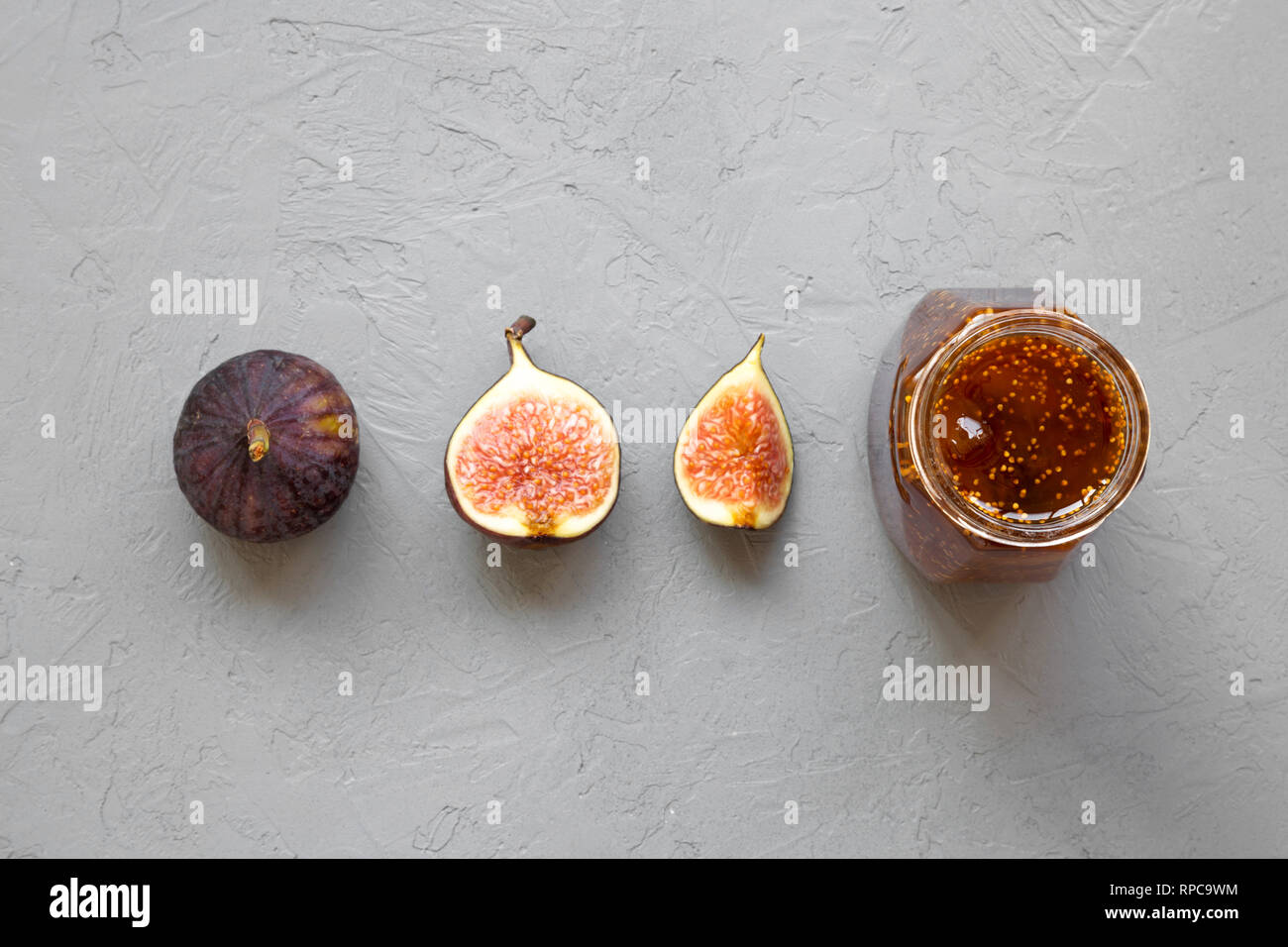 Top view, fig jam in glass jar and fresh figs on gray background. Flat ...