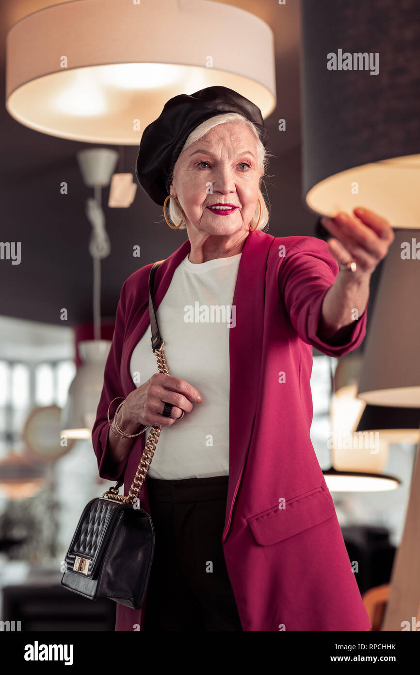 The portrait of sophisticated woman checking lamp quality in store ...