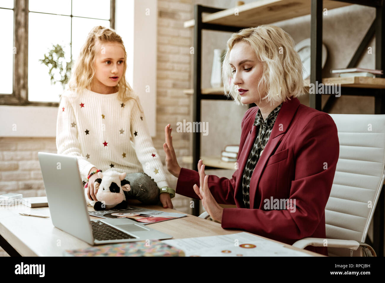Serious resolute woman in red jacket showing insufferable gesture Stock ...