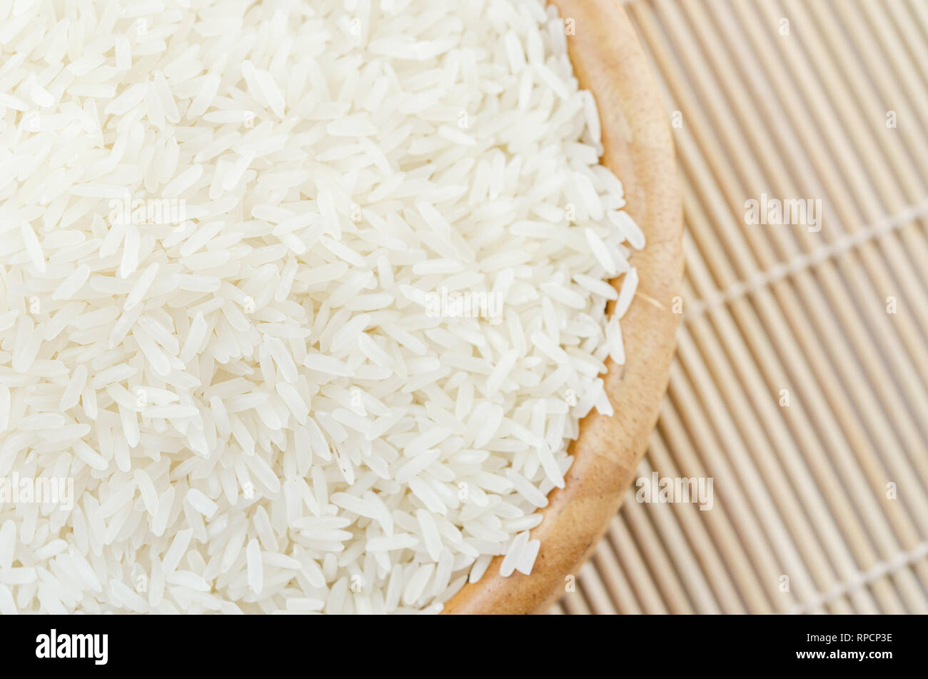 Raw white rice in wooden bowl Stock Photo - Alamy