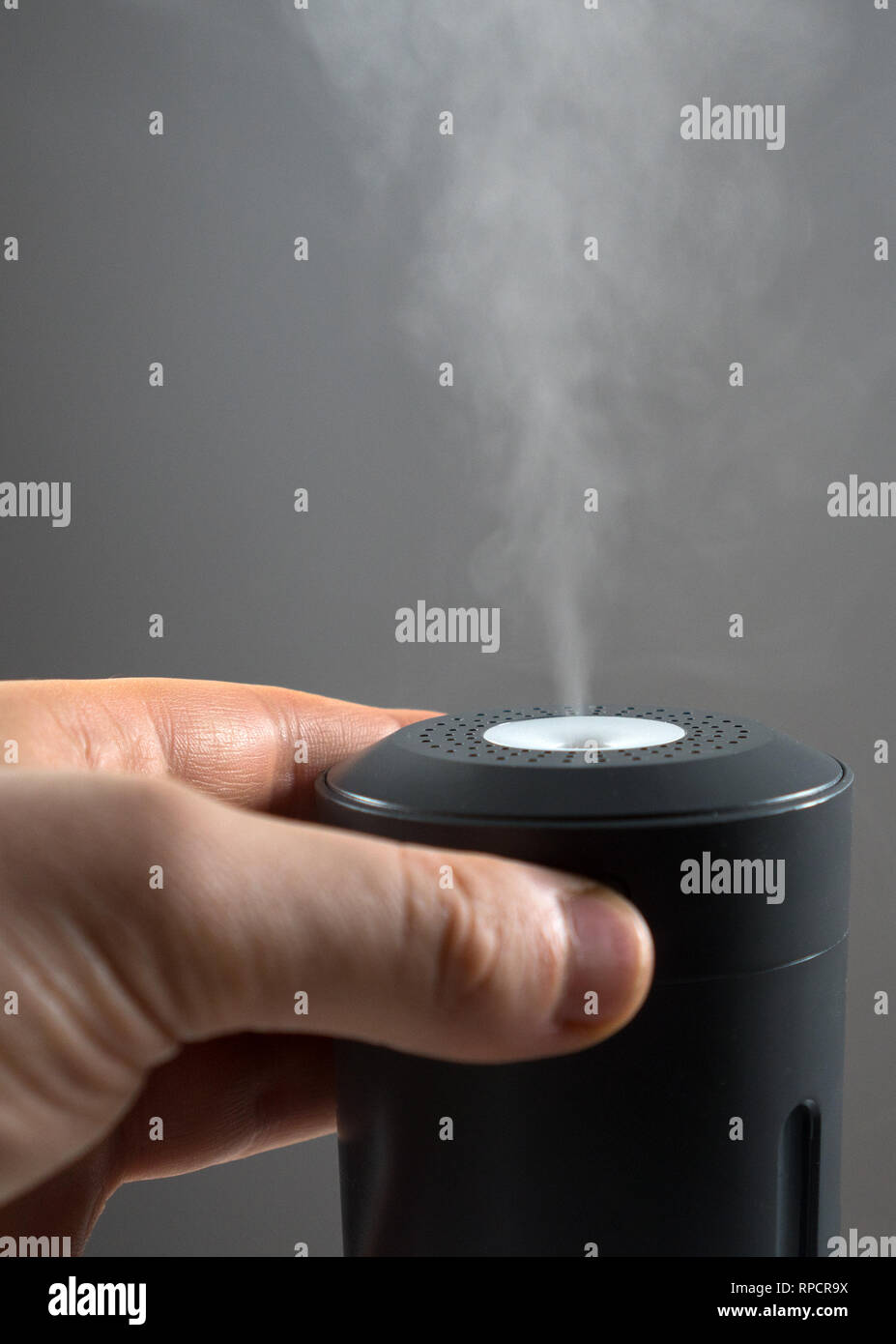Man's hand turning on electric air humidifier Stock Photo - Alamy