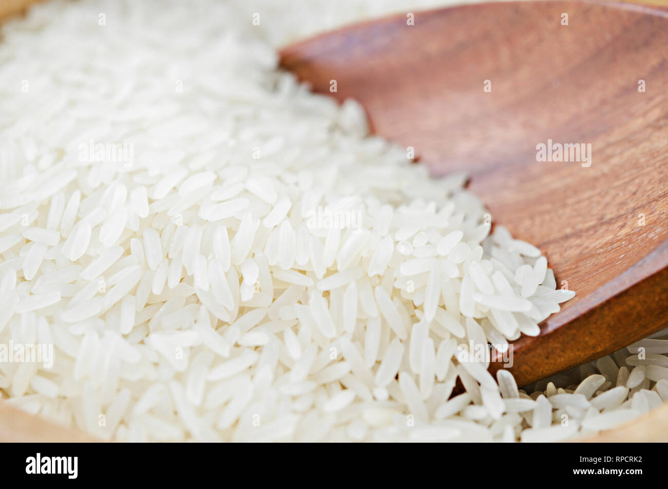 Close up raw white rice on wooden ladle Stock Photo - Alamy