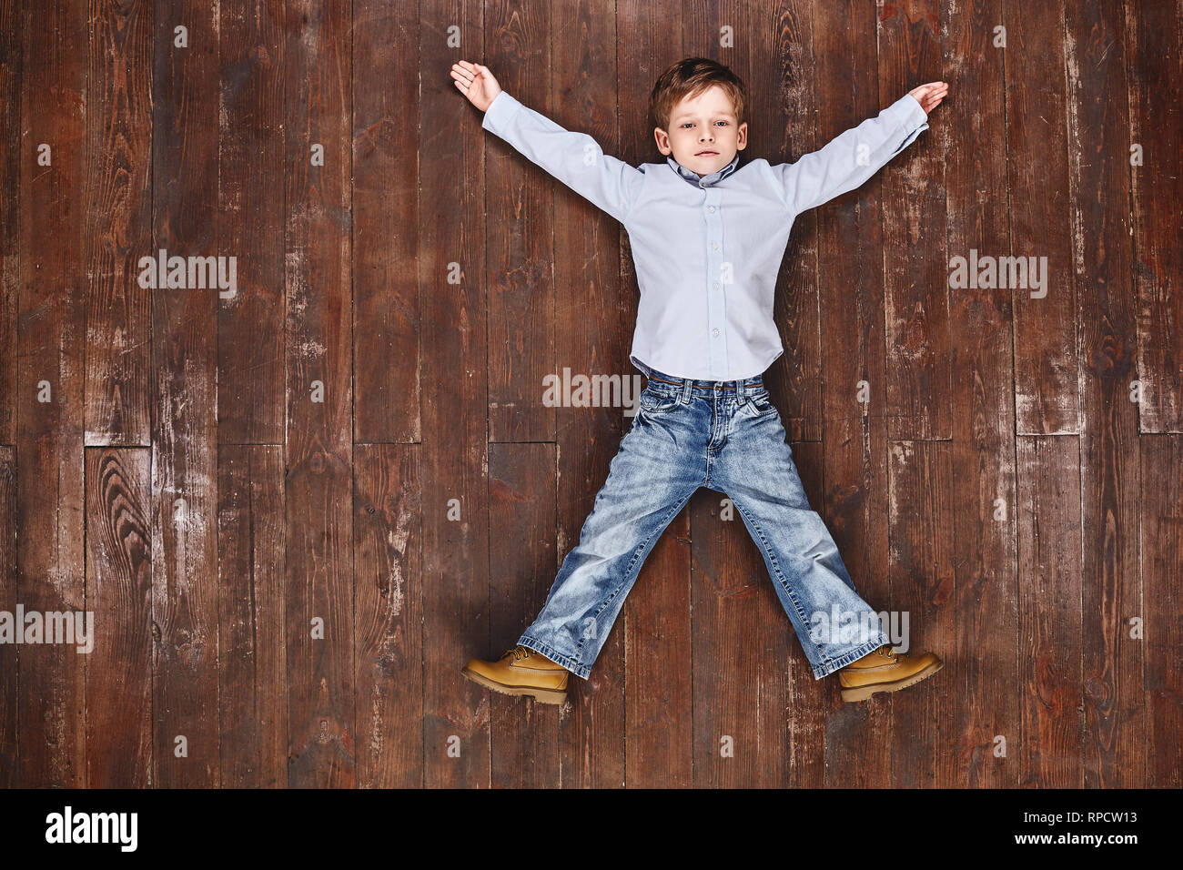 Happy child. Top view creative photo of little boy on vintage brown ...