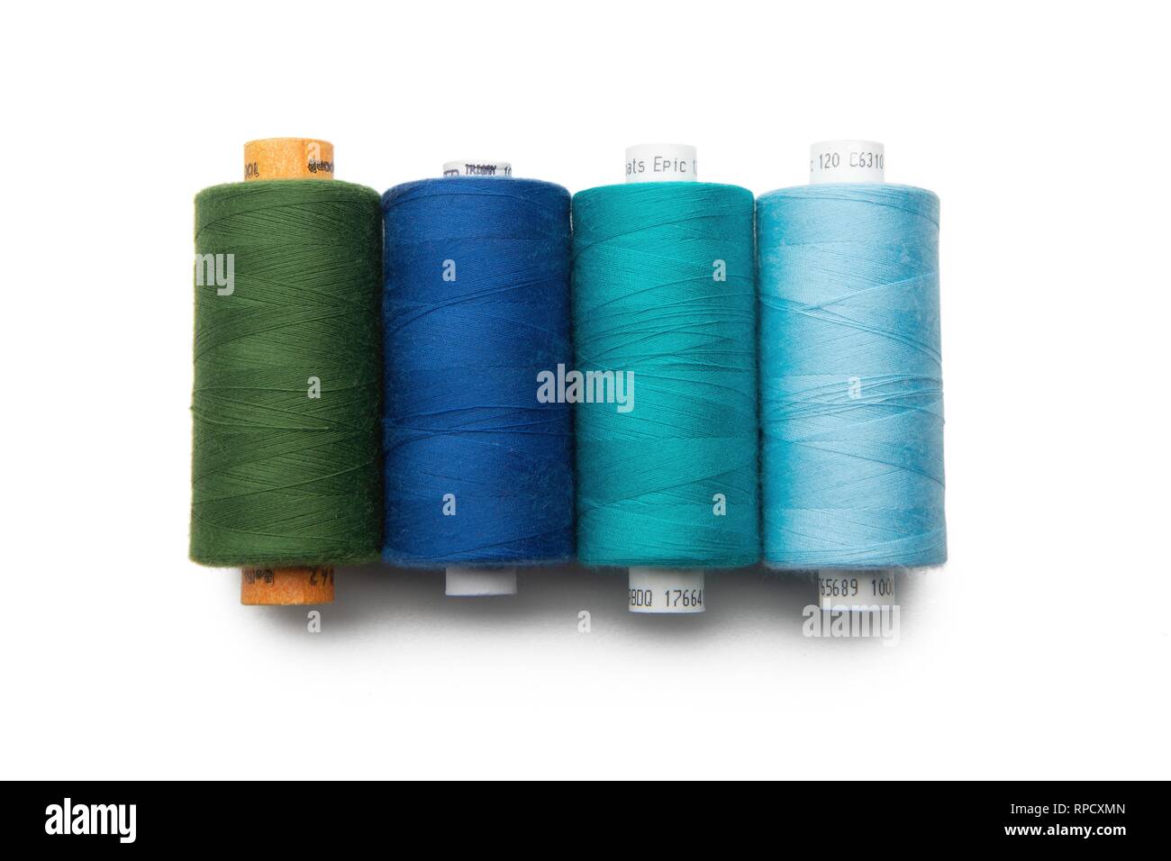 Rainbow colored sewing thread lined in a row Stock Photo - Alamy