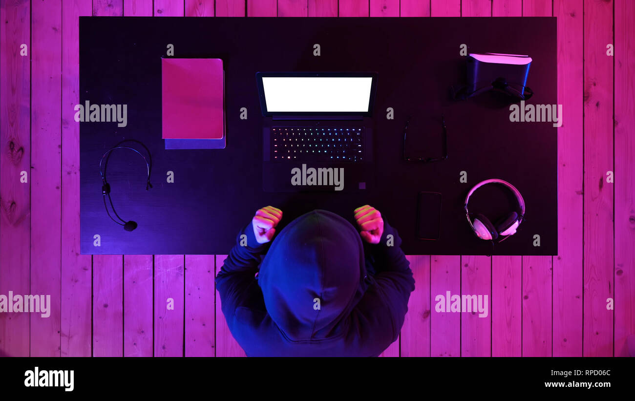 Top view. Lucky hacker won with his laptop. White Display. Professional ...