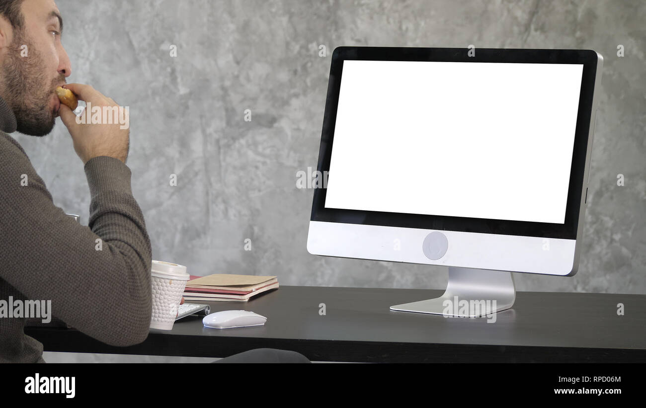 View to the screen of computer. Businessman eating food while having an ...