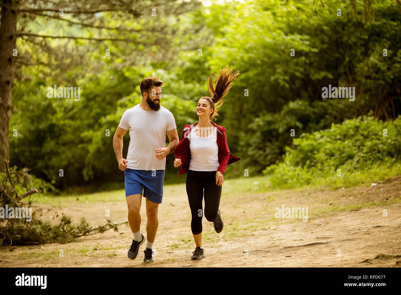 Healthy fit and sportive couple running in nature at summer day Stock ...