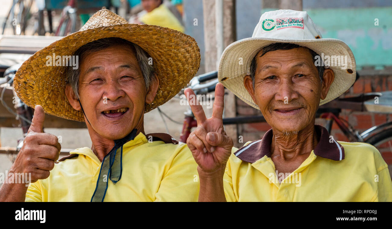 Portrait of two happy carefree old Vietmnamese men wearing hats ...