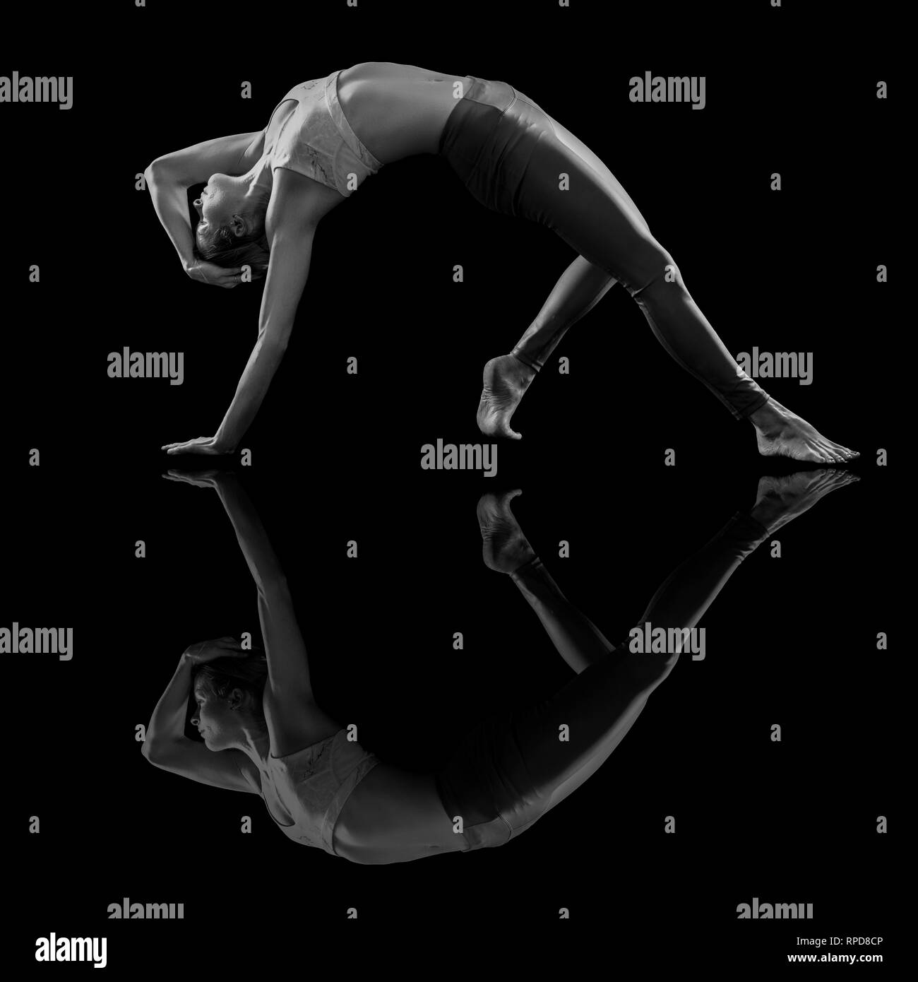 woman practicing yoga, 'wild thing' pose in the studio, black & white ...