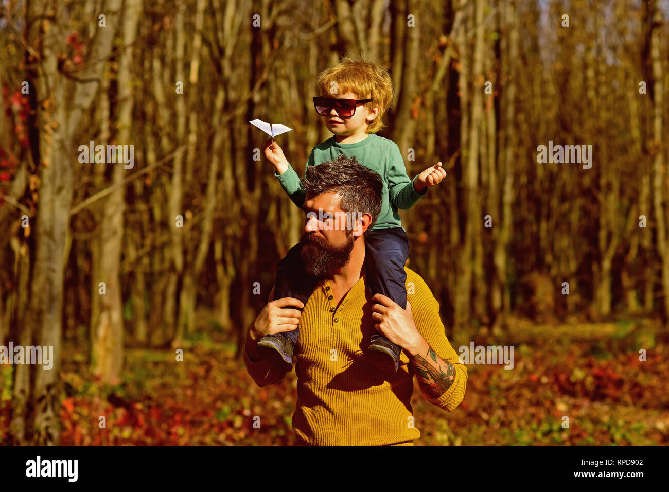 Father and child play together in park. Father and child launch paper ...