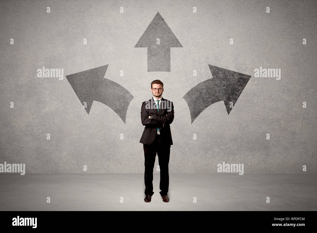 Charming businessman in doubt, choosing from three directions in front ...