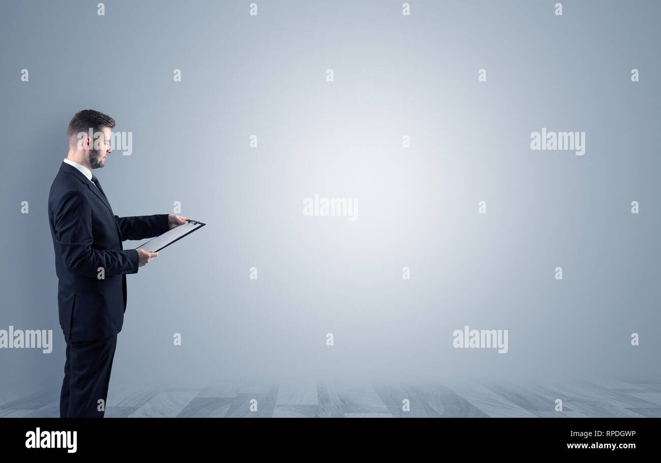 Elegant businessman standing and presenting something in an empty space ...