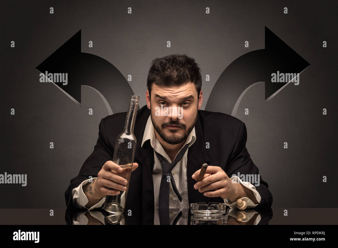 Drunk disappointed man sitting at table with arrows around Stock Photo ...