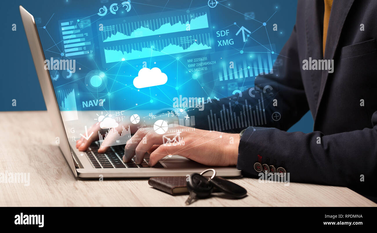 Businessman hand typing on laptop with reports and graphs concept ...
