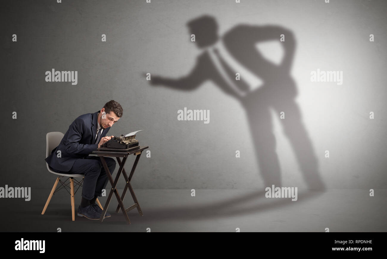 Little man working and a big shadow arguing with him Stock Photo - Alamy