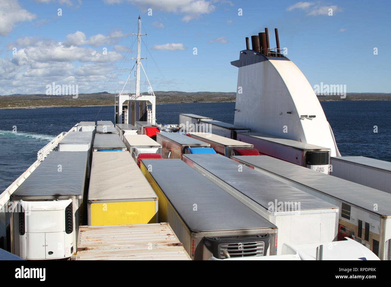 Transportation trucks waiting to get into hangar of ferryboat ship ...
