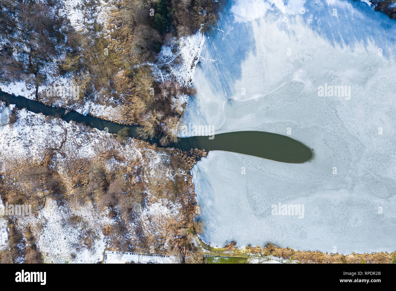 top view of the river flowing into the frozen lake. winter time Stock ...