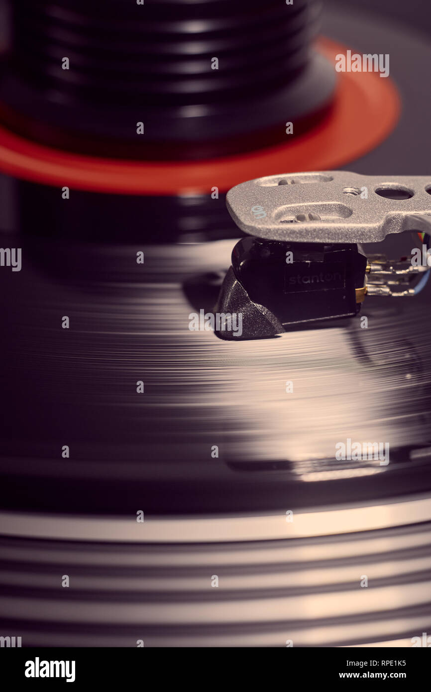 Vertical background of a rotating record and weight with the stylus ...