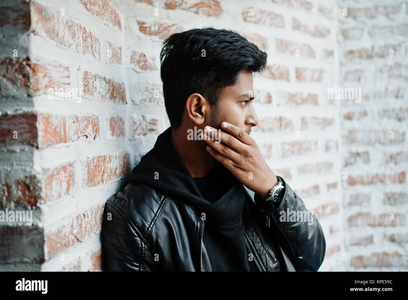 Smart young asian man wear on leather jacket posing against brick wall ...