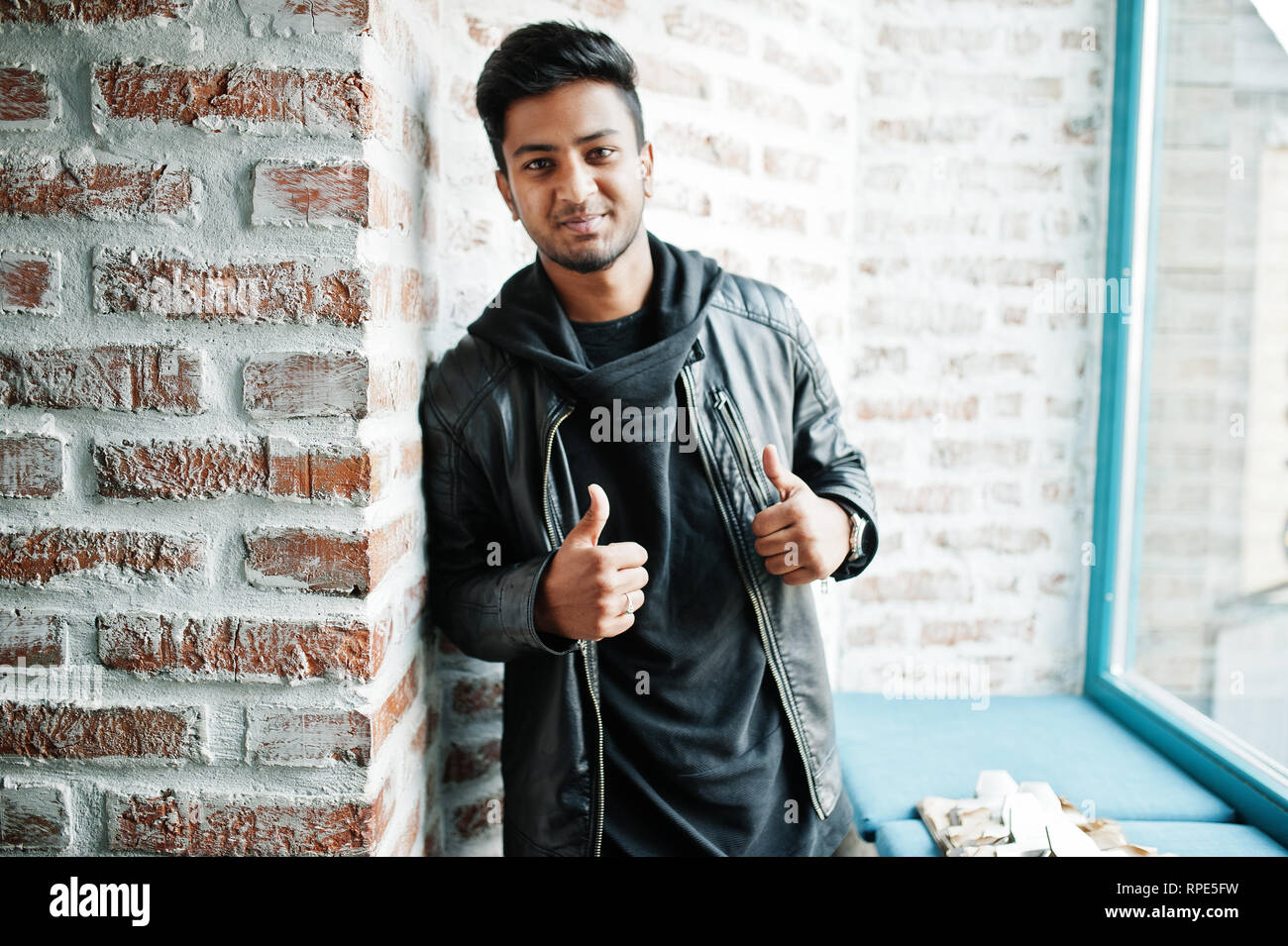 Smart young asian man wear on leather jacket posing against brick wall ...