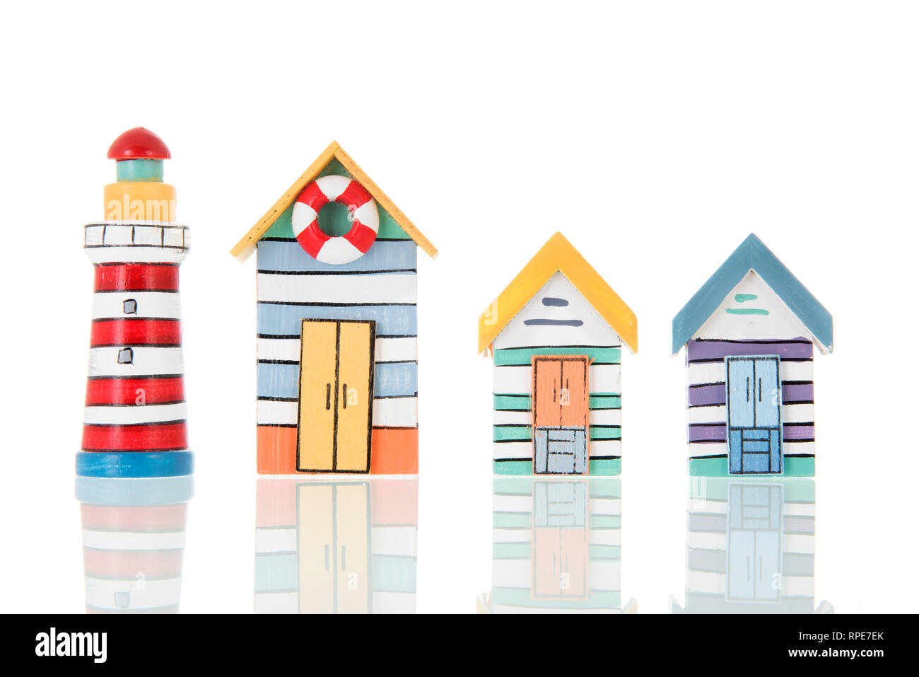 Miniature beach huts and light house isolated over white background ...