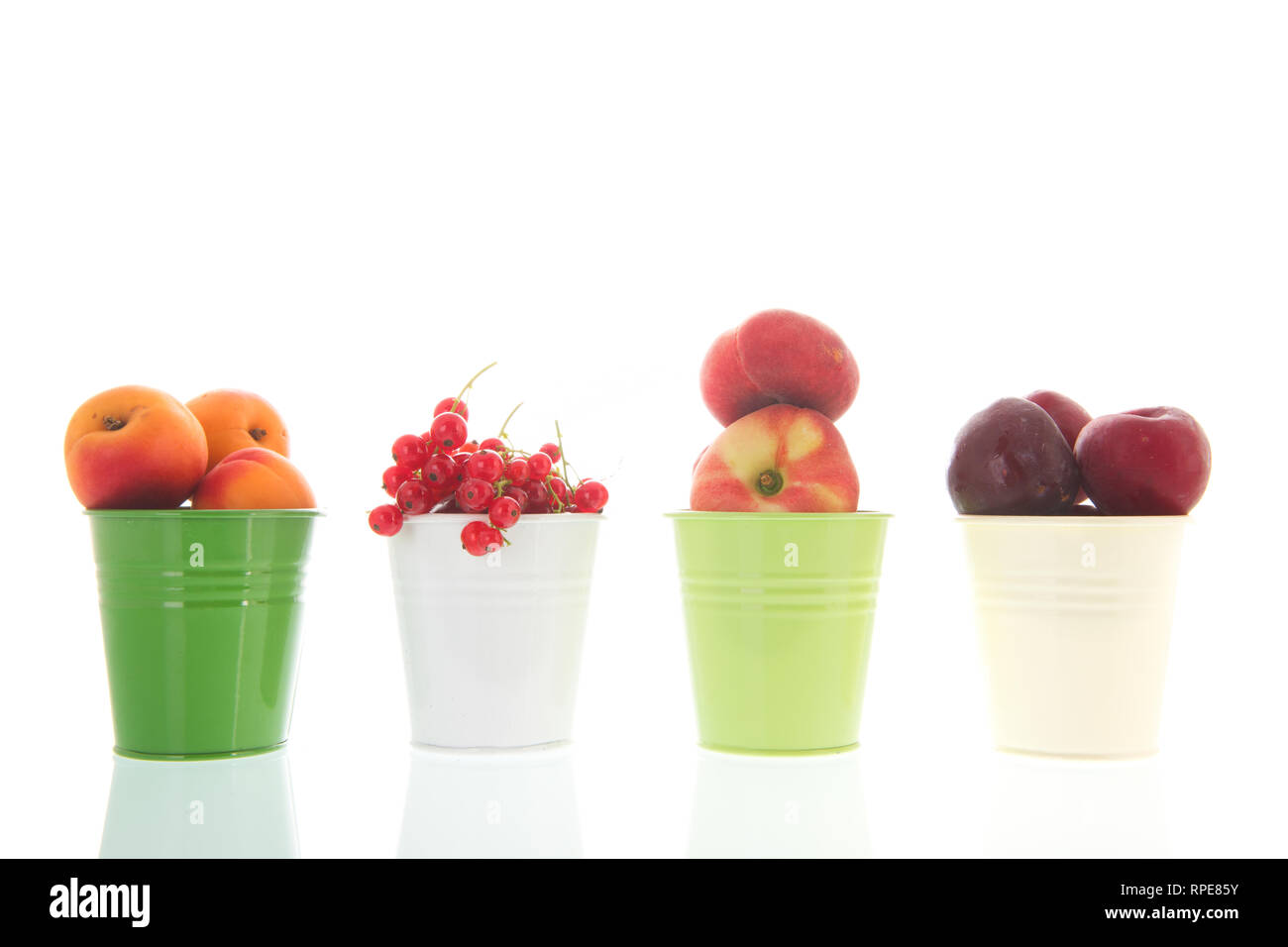 Green buckets with assortment fresh fruit isolated over white ...