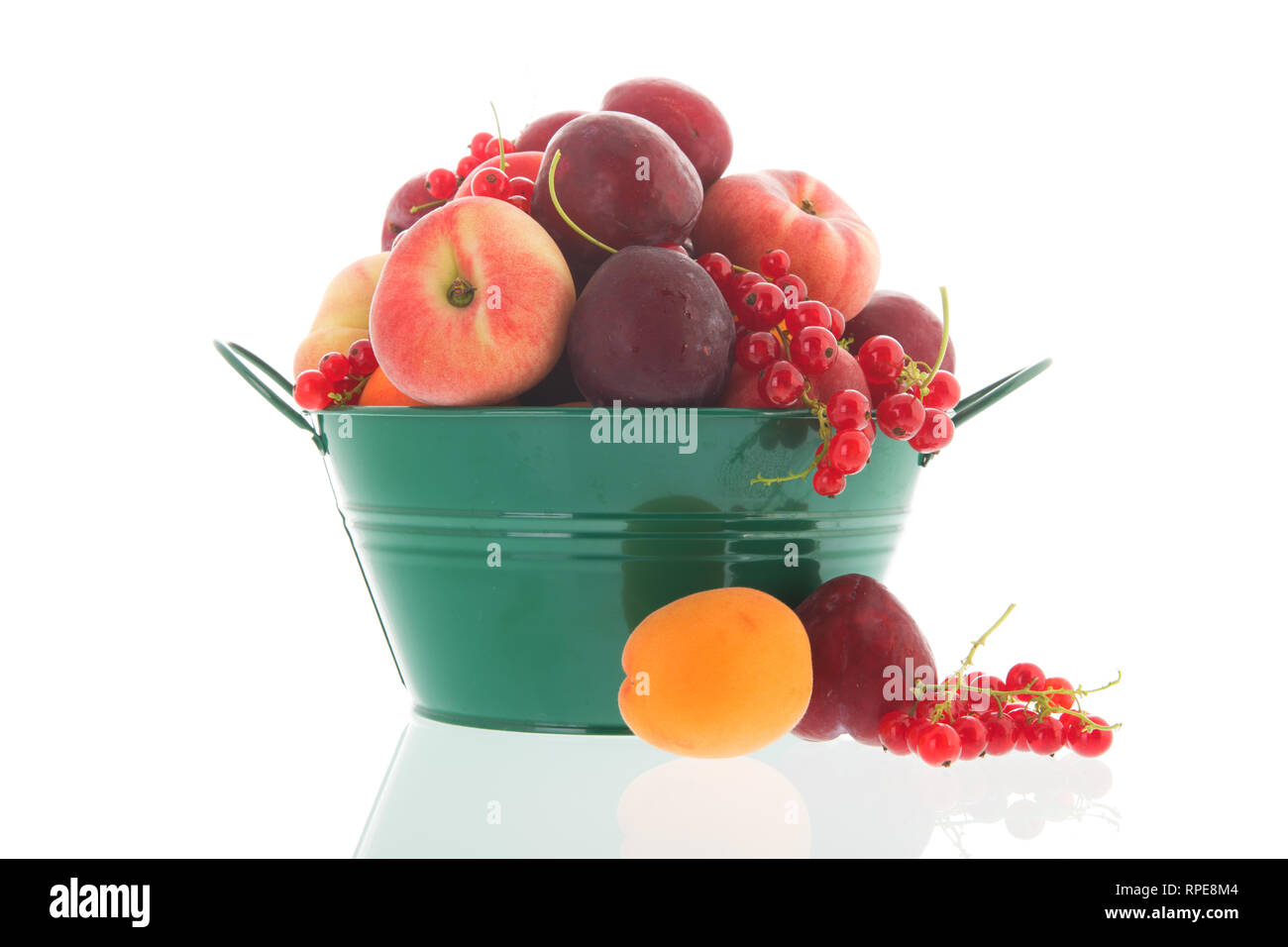 Green bucket full with fresh summer fruit isolated over white ...