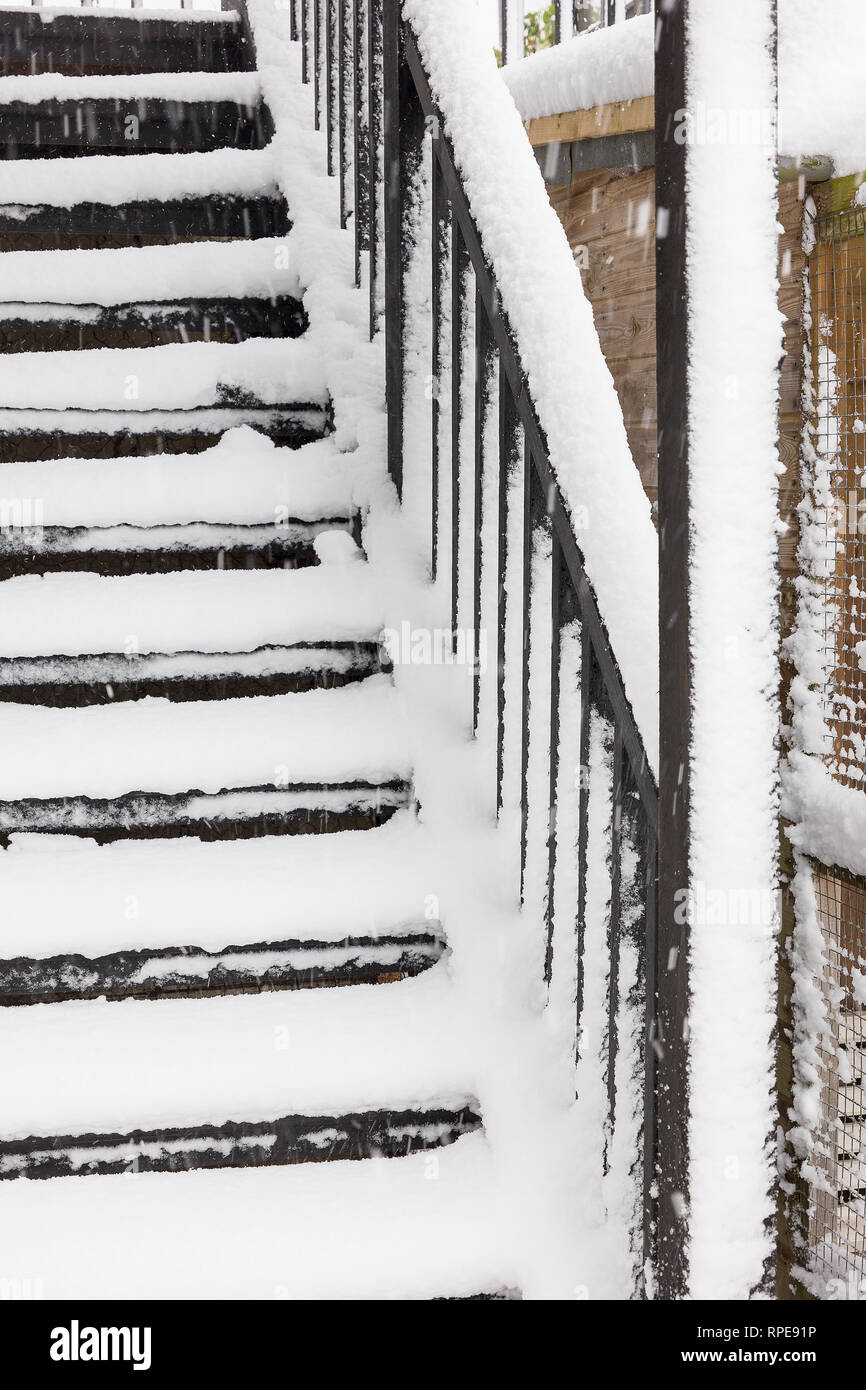 Exterior wooden stairway exposed to winter snow fall rendering access ...