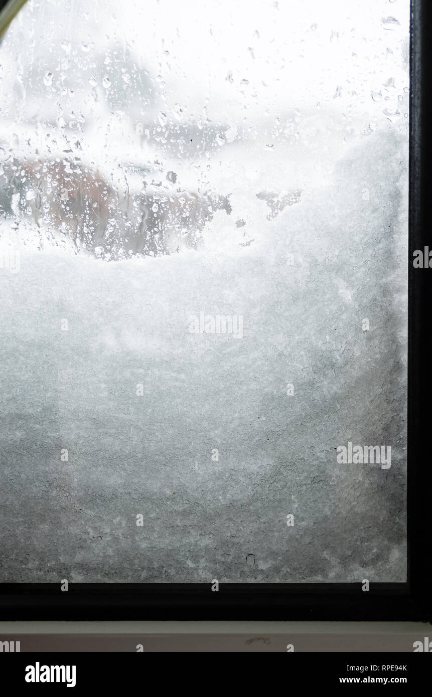 A build-up of drifting snow on the outside of a small double-glazed ...