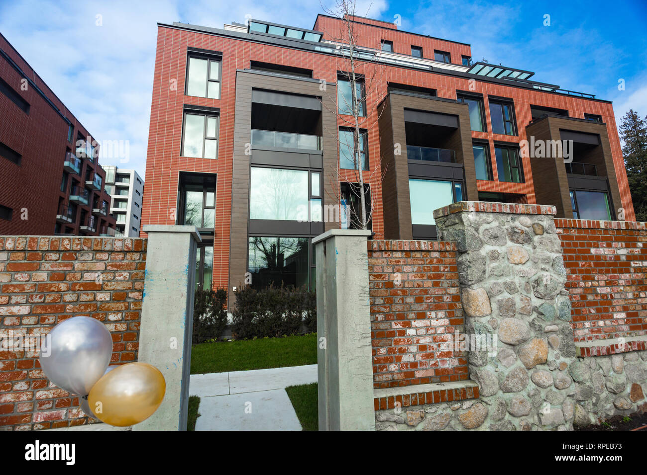 Modern Red Brick Apartment Complex with solid rock fence wall. Home ...
